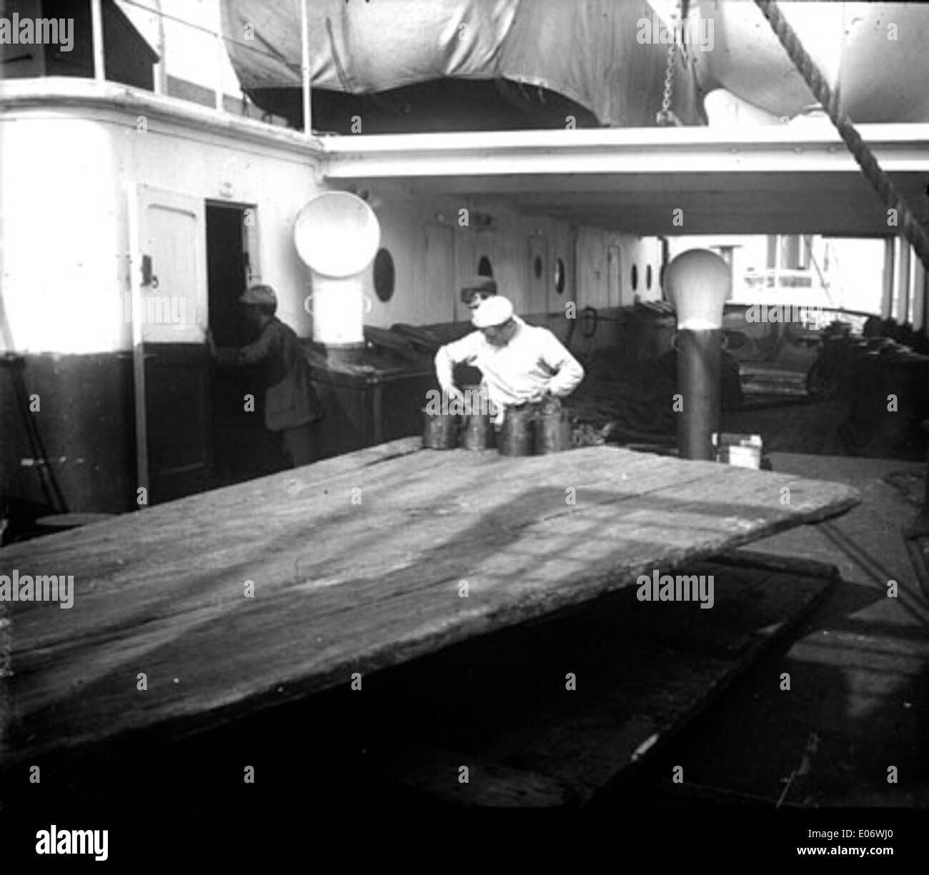 A photograph of a sailor working on the deck of a boat, capturing the ...