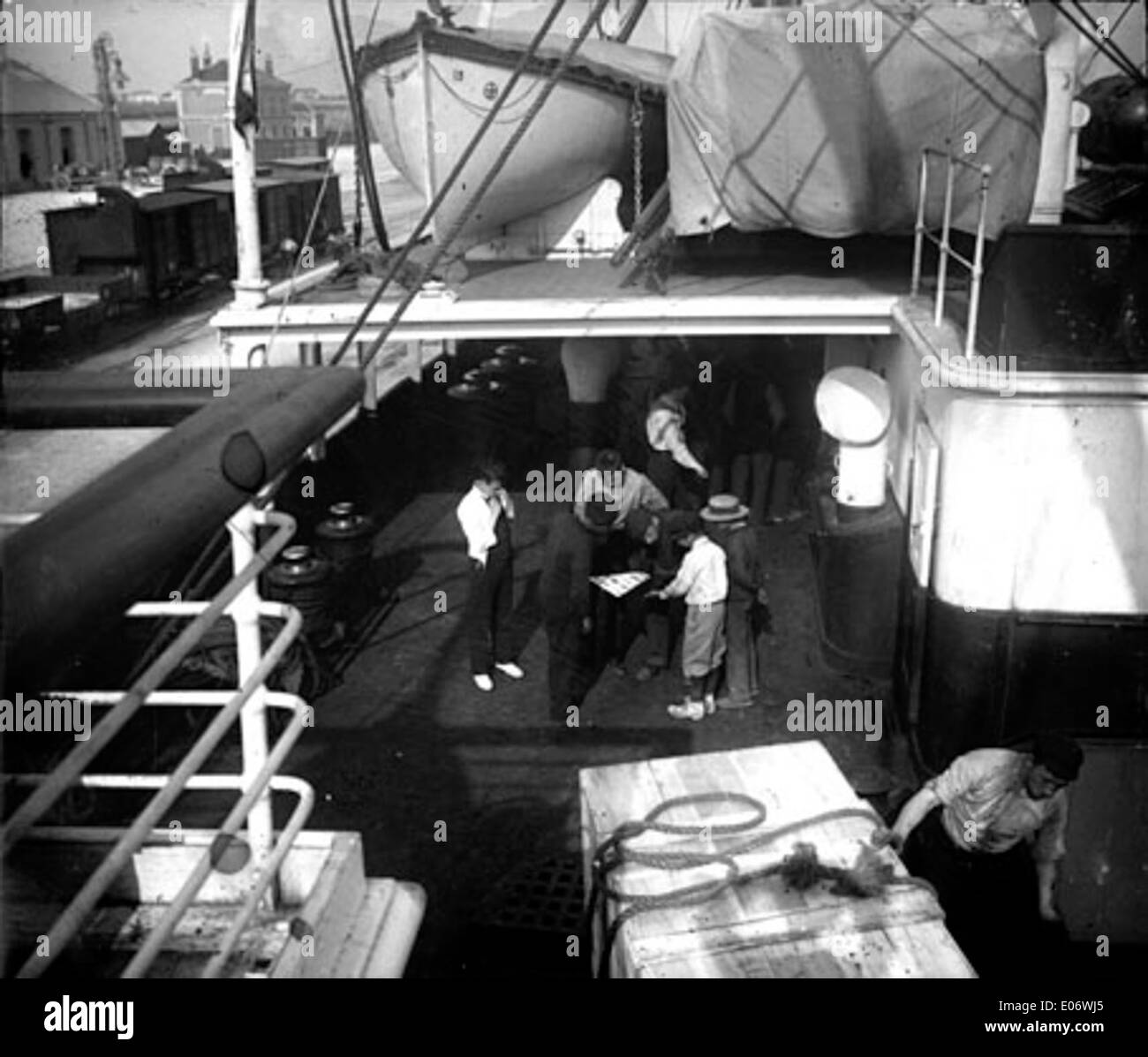 A photograph showing a group of men having a discussion on a boat. The ...