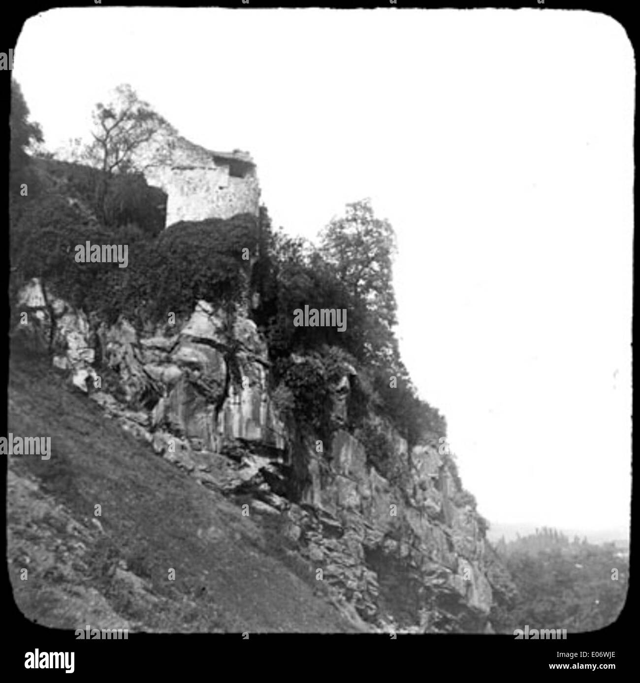 A photograph of a ruined castle tower on a rocky outcrop. The castle is ...