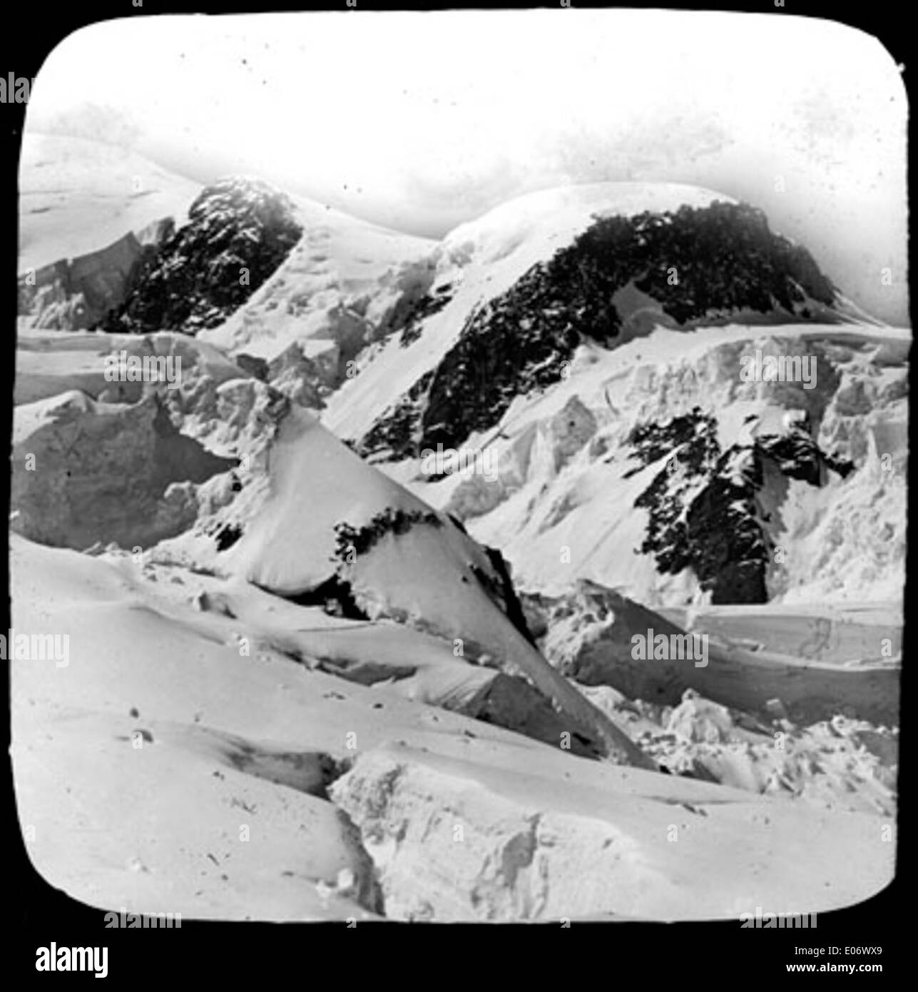 A photograph of a snow-covered corridor with red rocks along the path ...