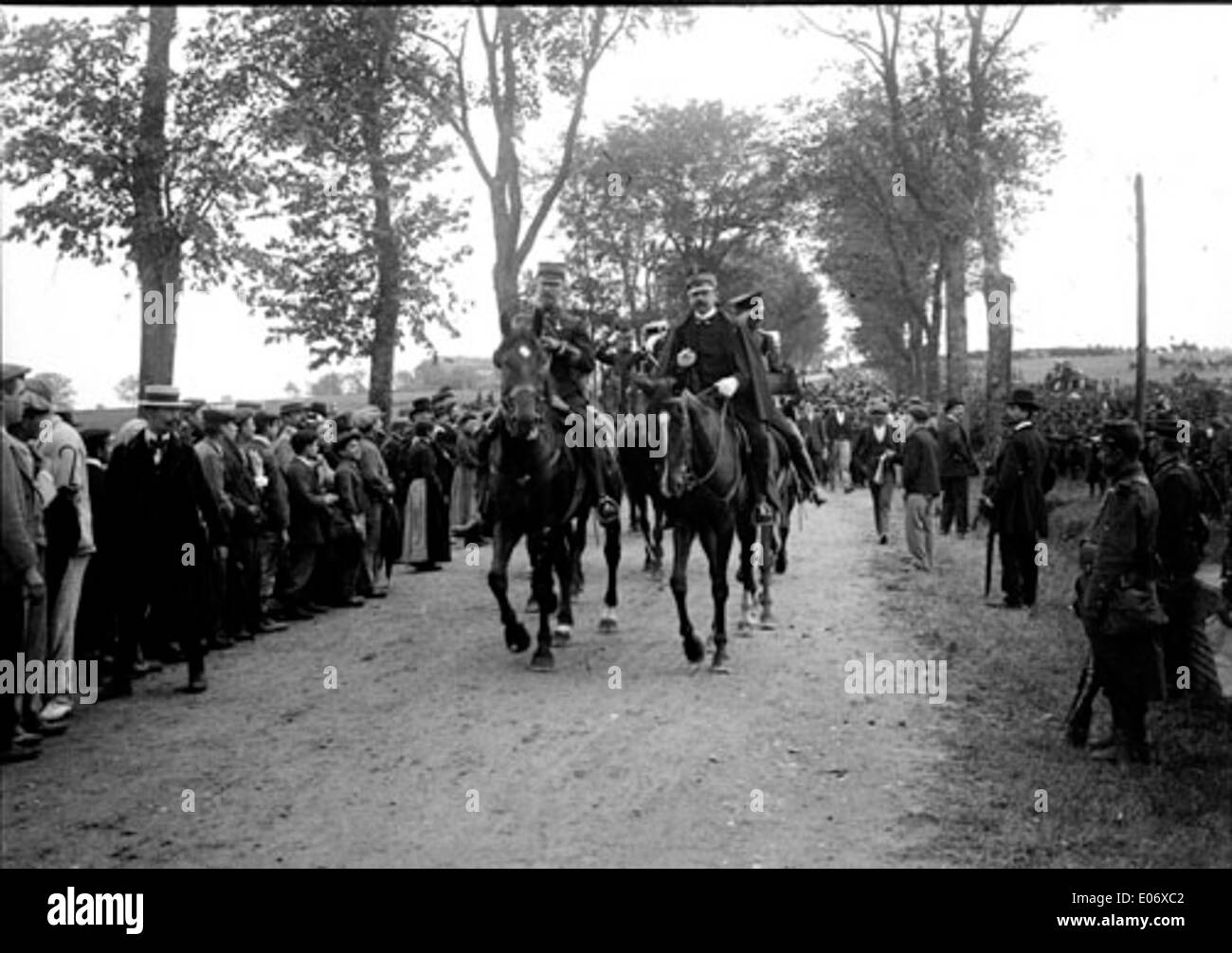 A photograph depicting a military procession along a tree-lined country ...