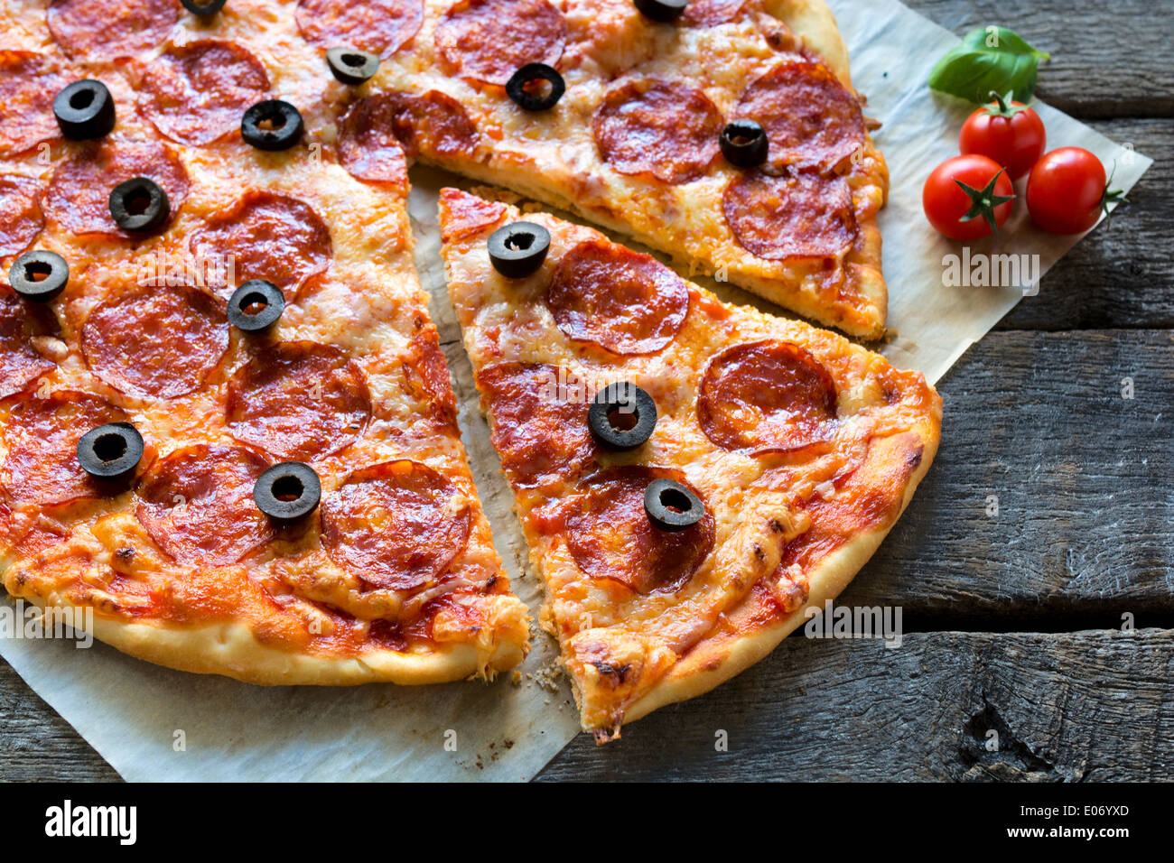 Slice of shole pepperoni pizza on wooden background.Selective focus in ...