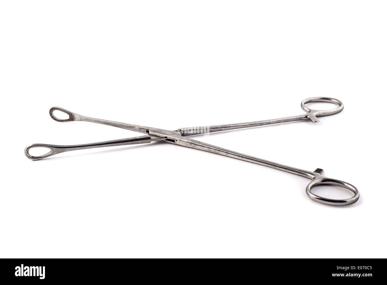 a pair of stainless steel surgical forceps over a white background ...