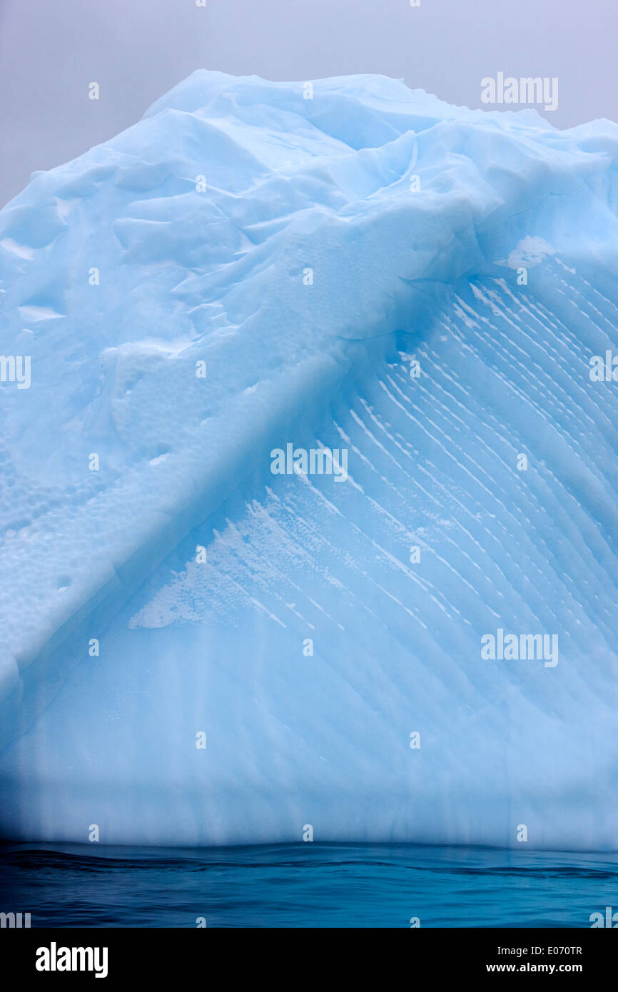 iceberg showing straight striped lines and water line erosion near ...