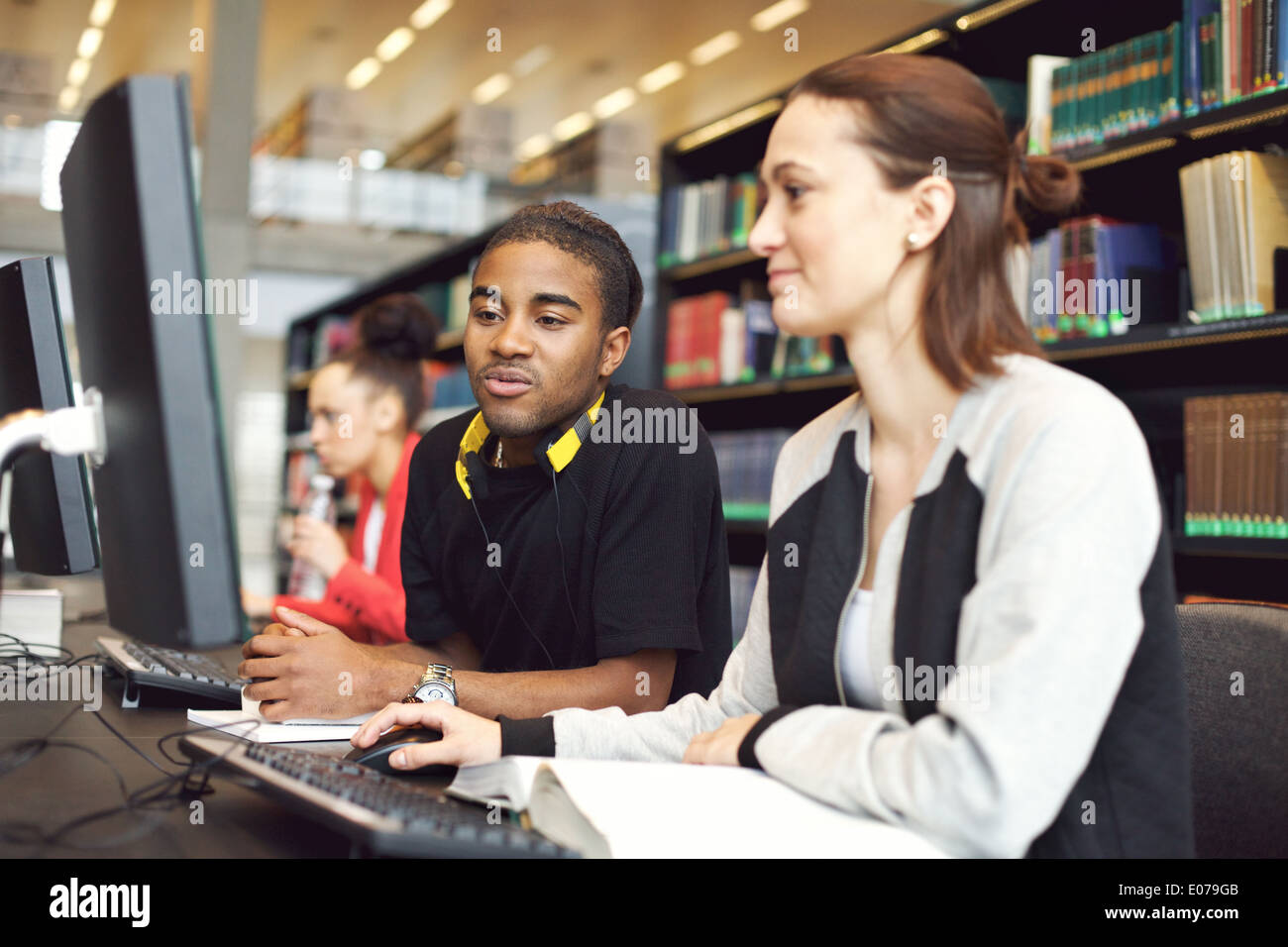 Young university students sitting at table using computers for research ...