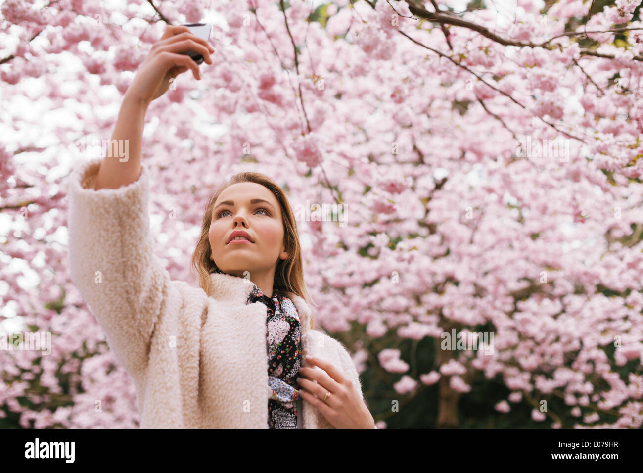 Beautiful young lady photographing nature with her mobile phone. Pretty ...