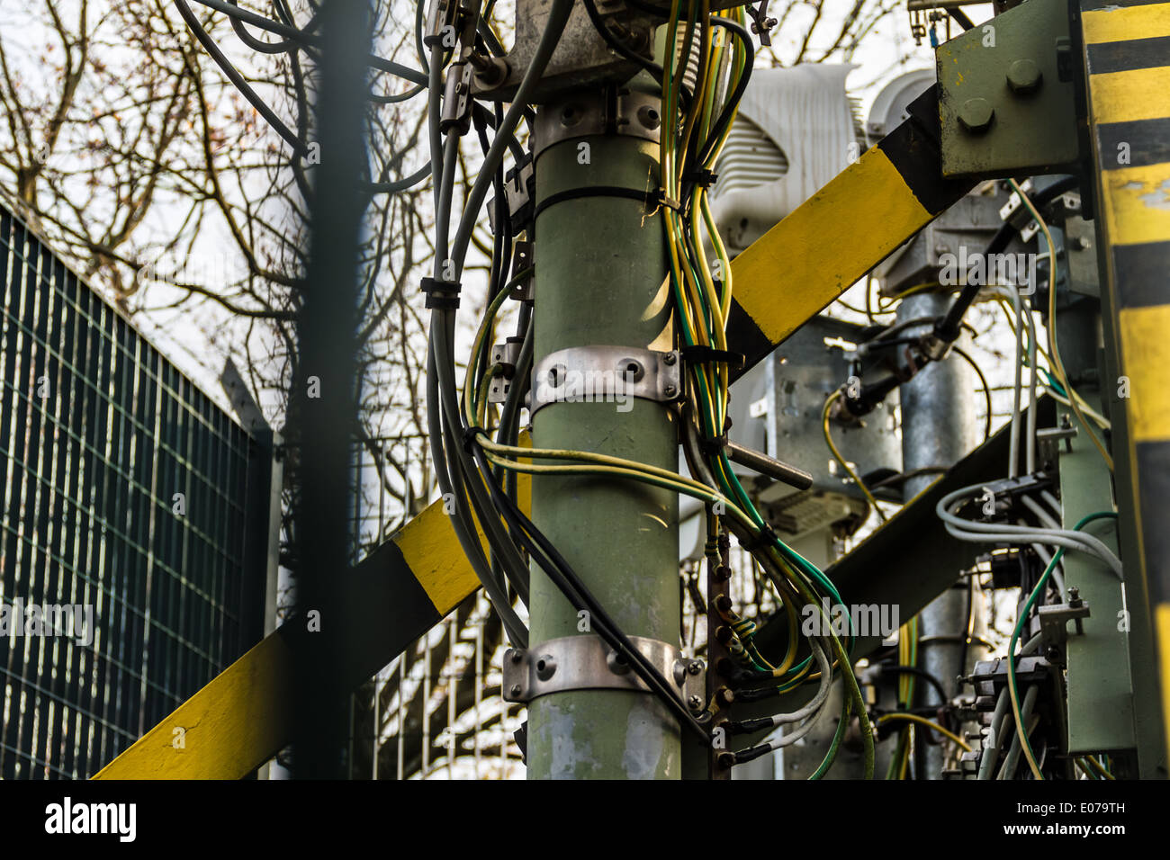 base of a communication tower with various equipment and tangled wires ...