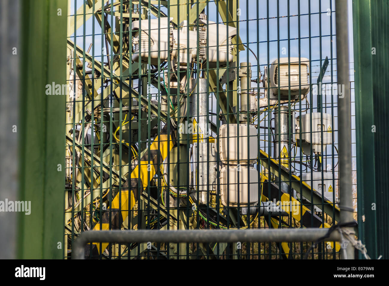 base of a communication tower with various equipment and tangled wires ...