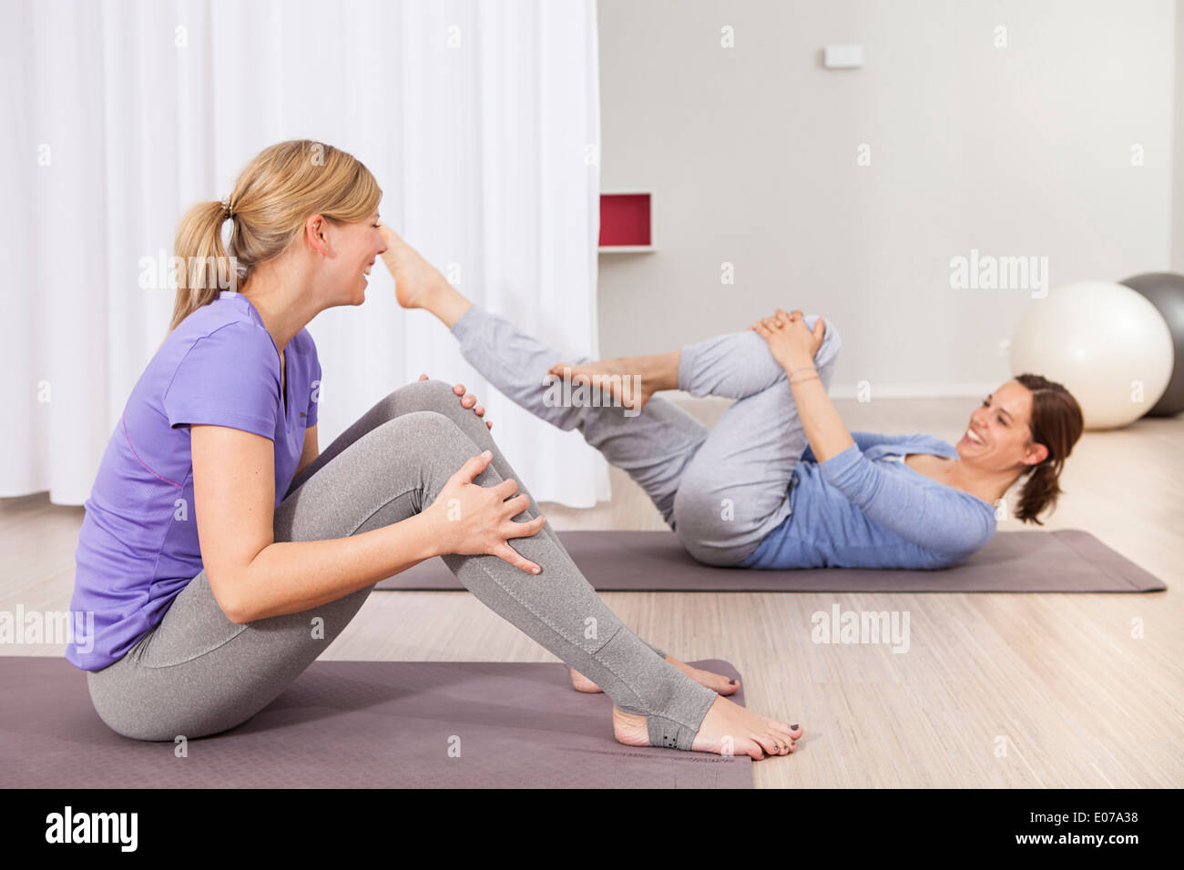 Two women doing Pilates exercises having fun Stock Photo - Alamy
