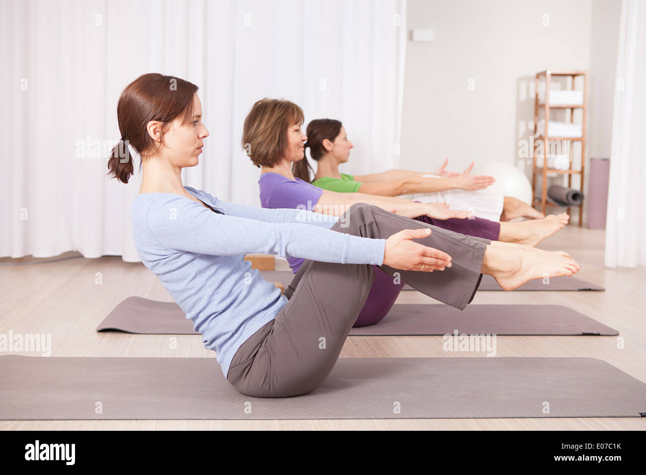 Three women doing Pilates exercises in gym Stock Photo - Alamy