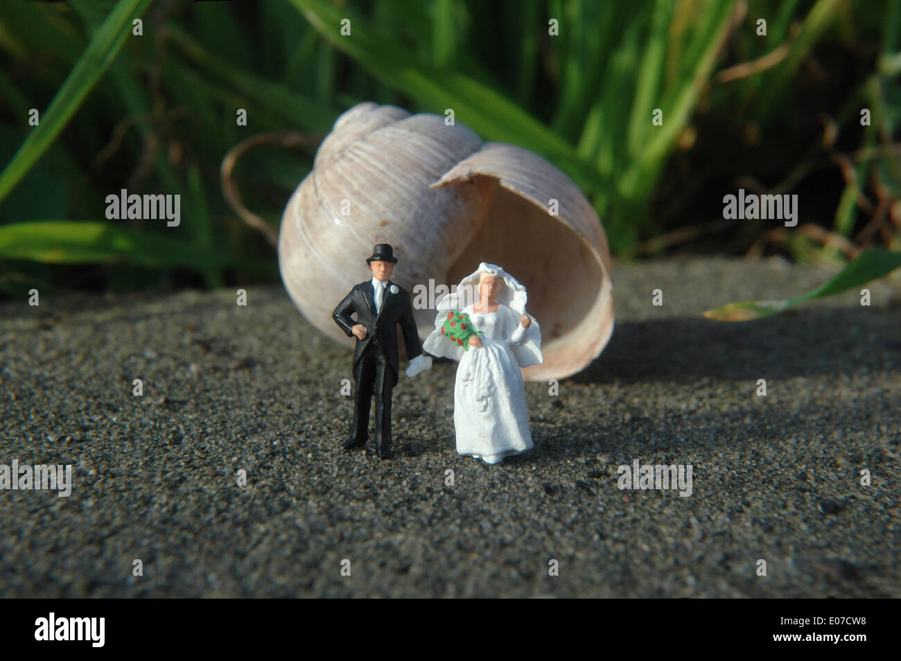 Illustration - Midget figures of a wedding couple stand in front of a ...