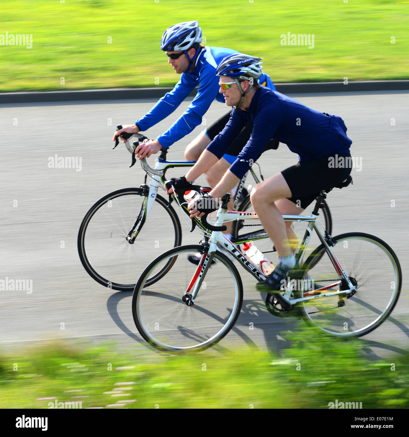 Two cyclists ride their bikes on the road Stock Photo - Alamy