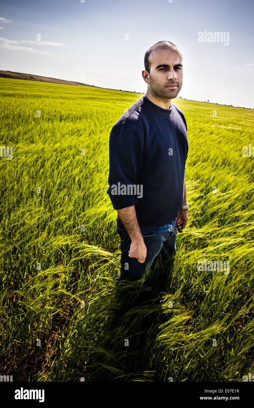 a lone man walking in a big green field Stock Photo - Alamy