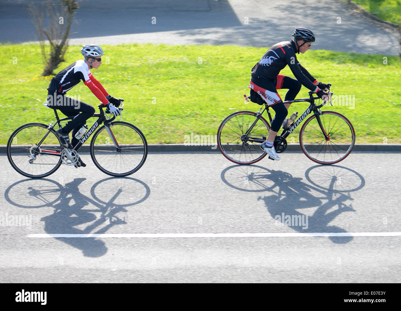 Two cyclists ride their bikes on the road Stock Photo - Alamy