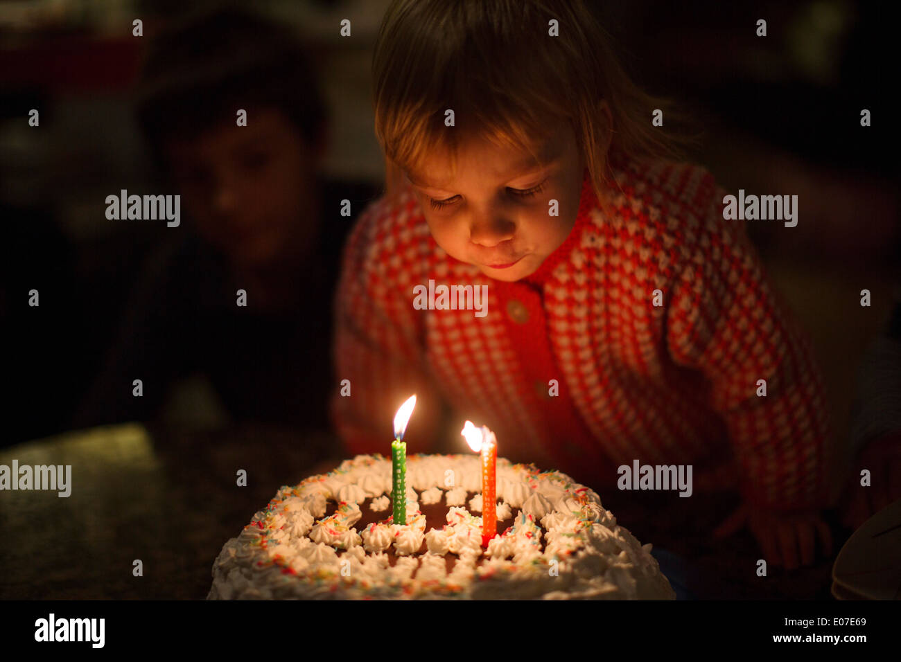 Little girl blowing out birthday candles on cake Stock Photo - Alamy