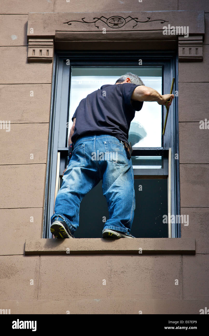 Hang on Tight, Window Cleaner Hanging Out Of A Building Stock Photo - Alamy