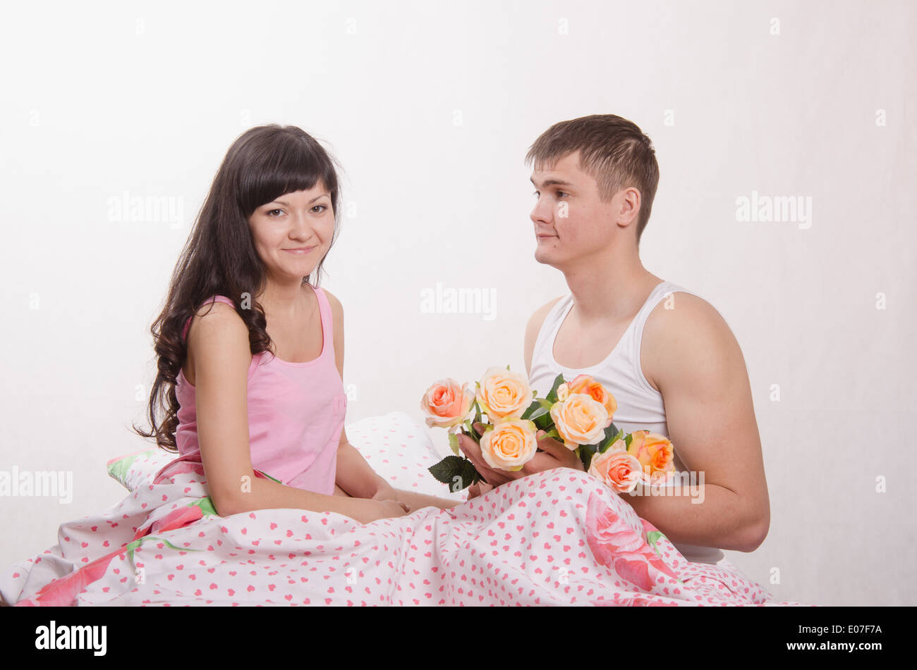 Young beautiful girl gives flowers to a young guy Stock Photo - Alamy