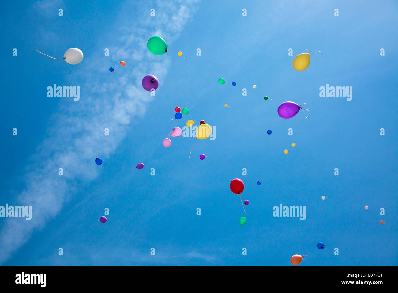 Multi-colored balloons flying in the blue sky Stock Photo - Alamy