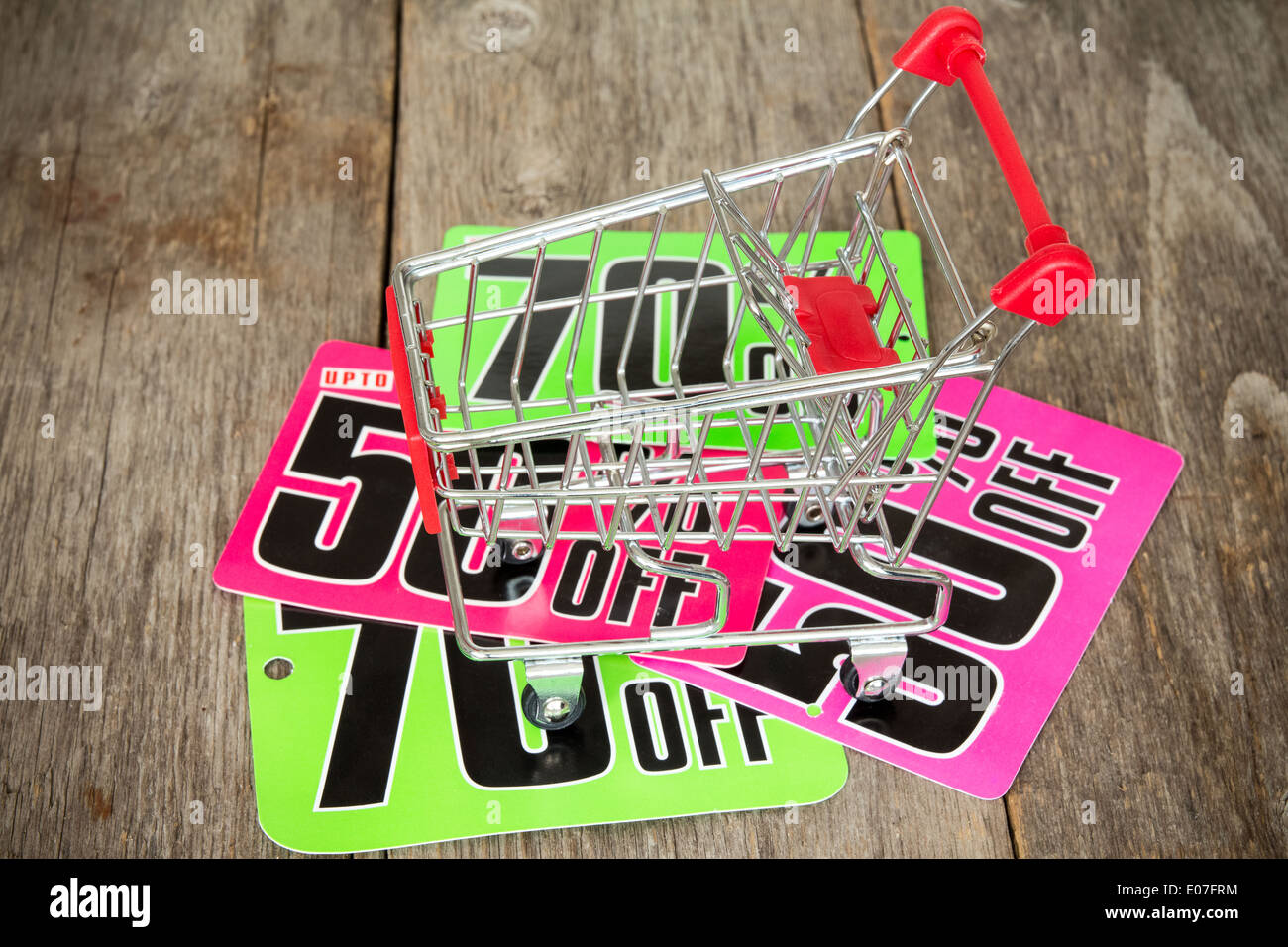 Shopping cart and sale tags on the wood background Stock Photo - Alamy