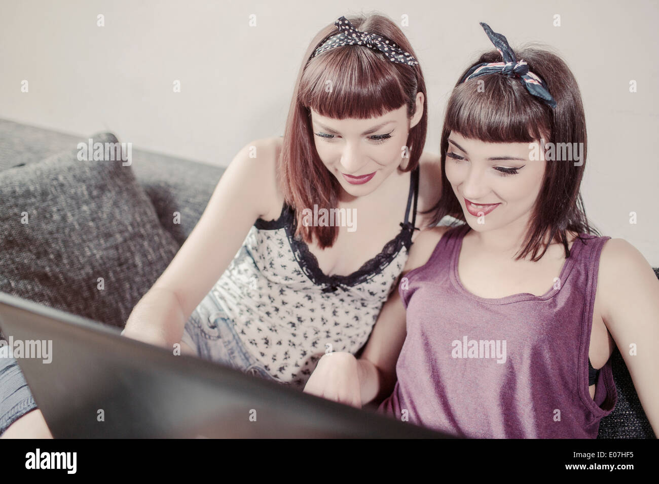 Two young women side by side using laptop computer Stock Photo - Alamy