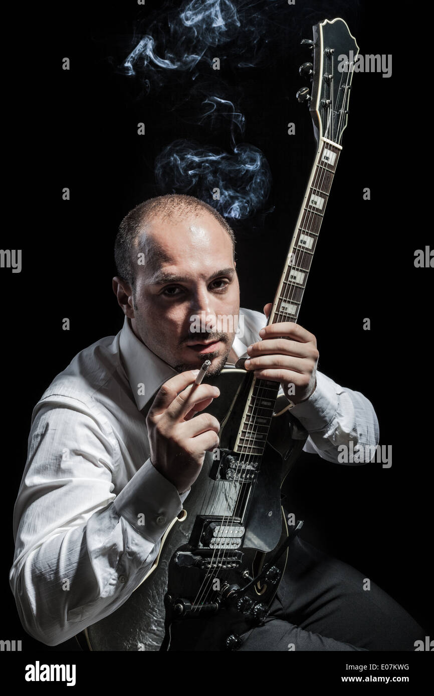 a young jazzer with a black acoustig guitar over black background Stock ...