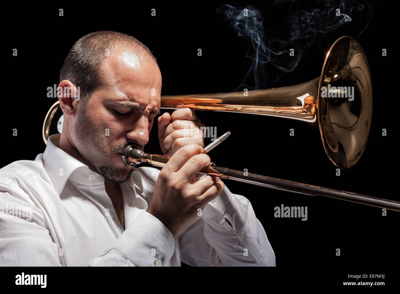 a young jazzer with a trombone over black background Stock Photo - Alamy