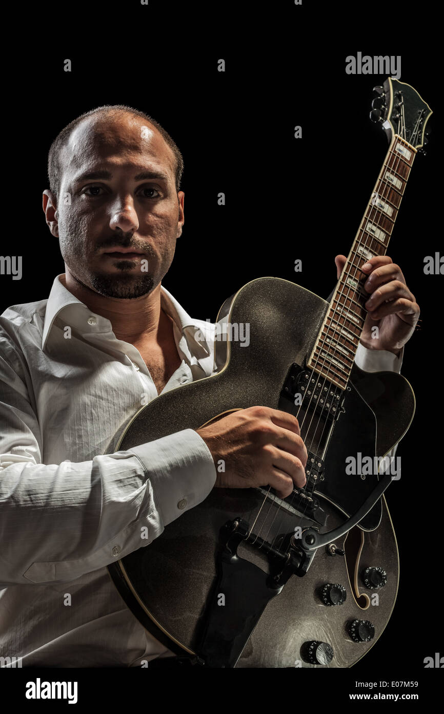 a young jazzer with a black acoustig guitar over black background Stock ...