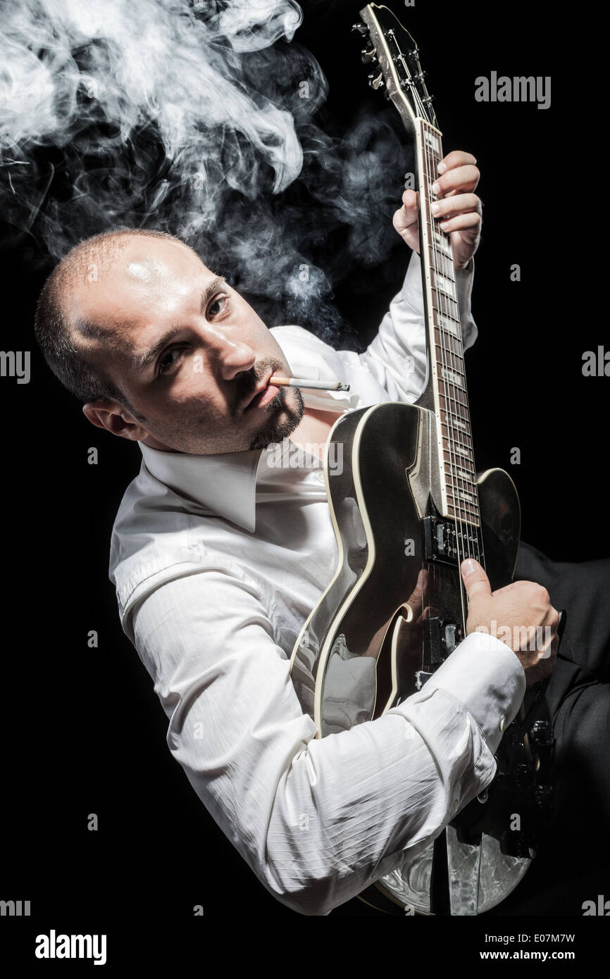 a young jazzer with a black acoustig guitar over black background Stock ...