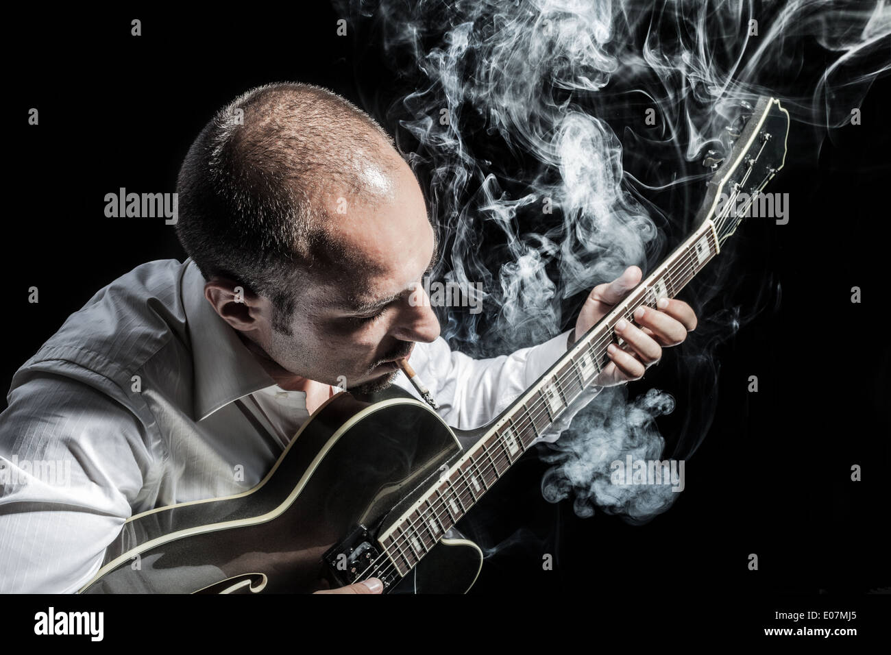 a young jazzer with a black acoustig guitar over black background Stock ...