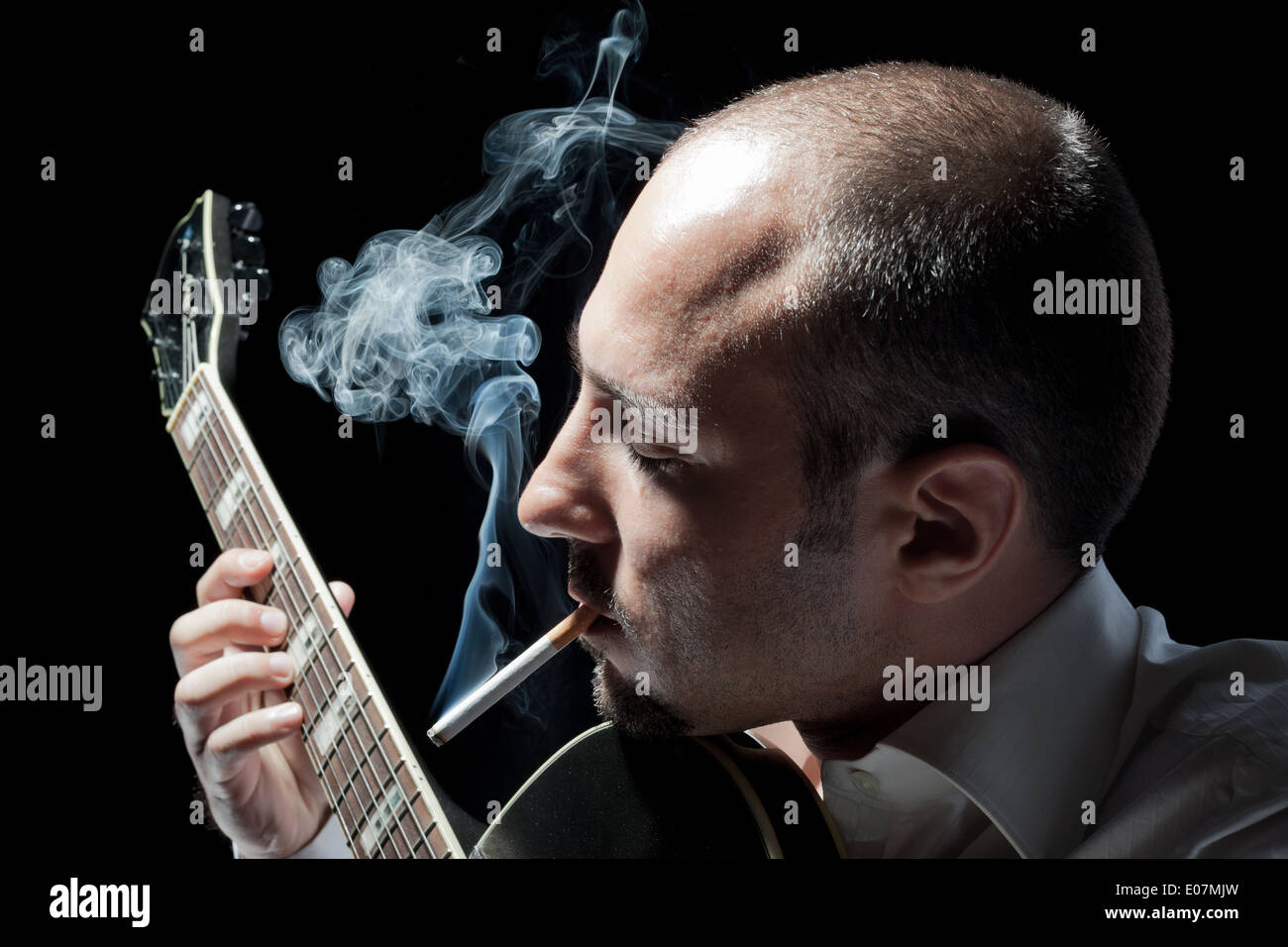 a young jazzer with a black acoustig guitar over black background Stock ...