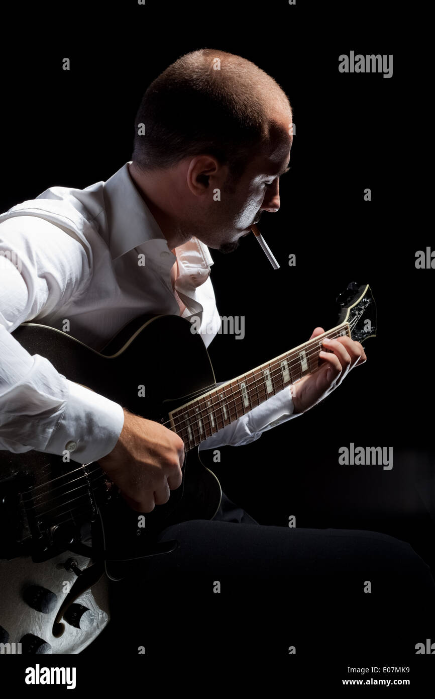 a young jazzer with a black acoustig guitar over black background Stock ...