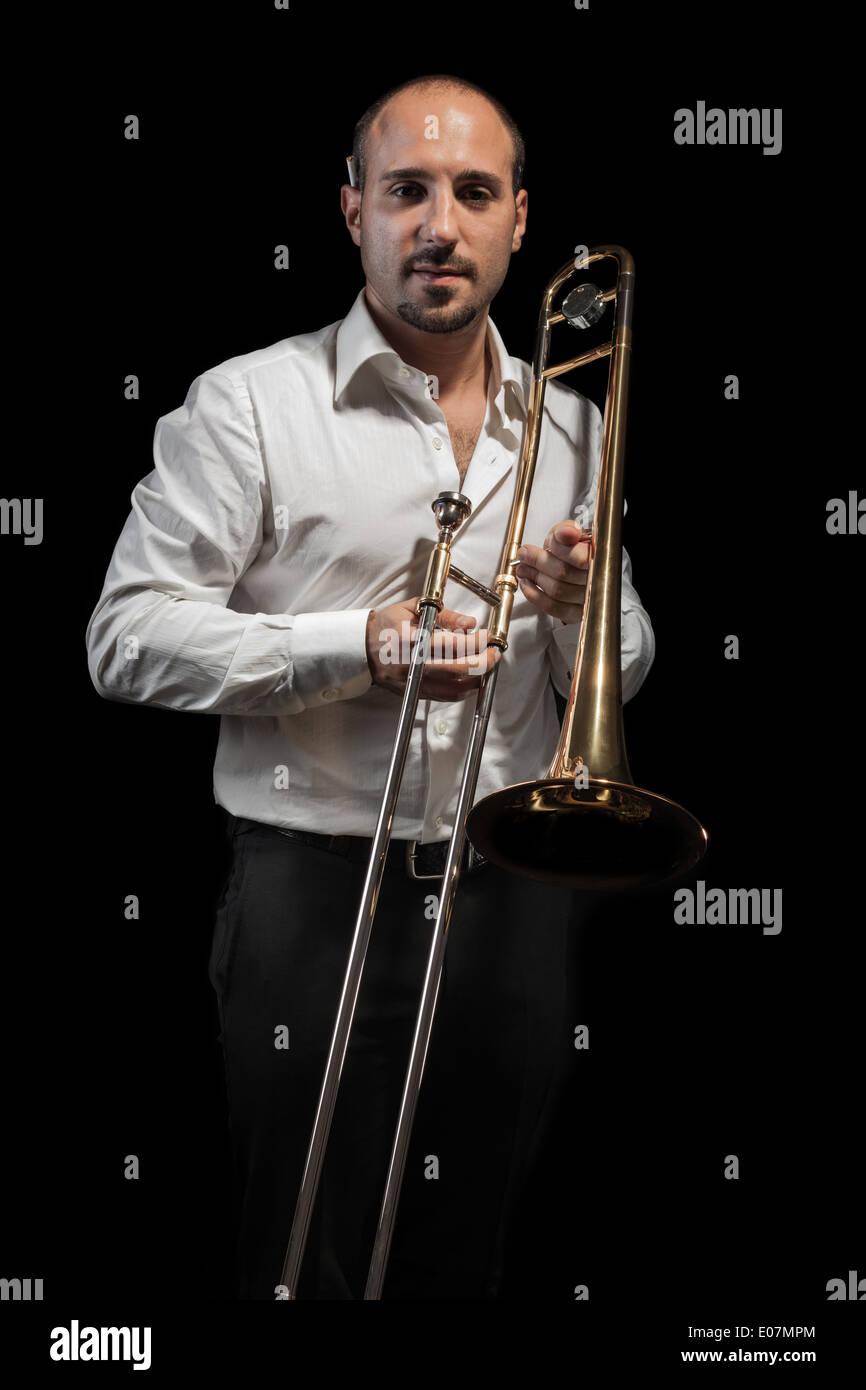 a young jazzer with a trombone over black background Stock Photo - Alamy