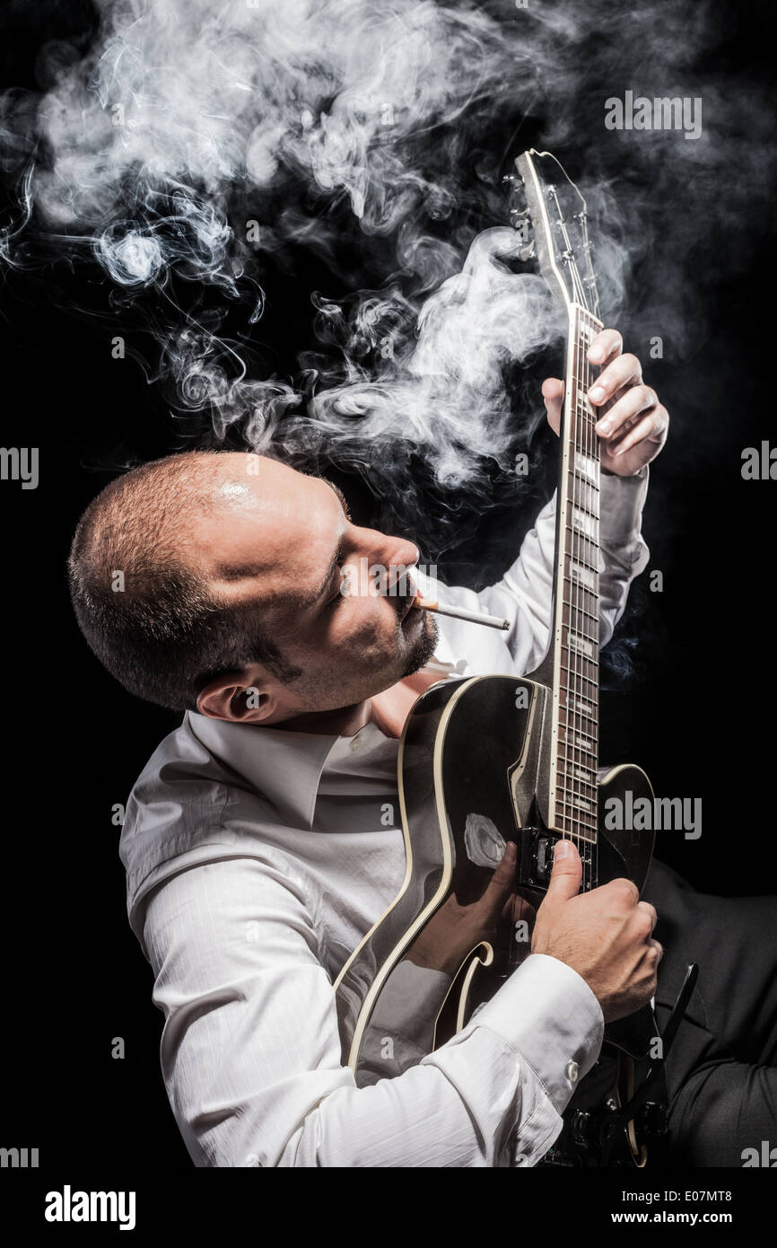 a young jazzer with a black acoustig guitar over black background Stock ...