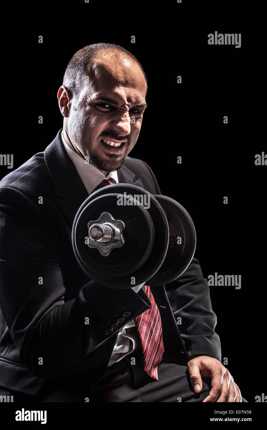 a serious businessman wearing a suit and lifting two heavy weight Stock ...