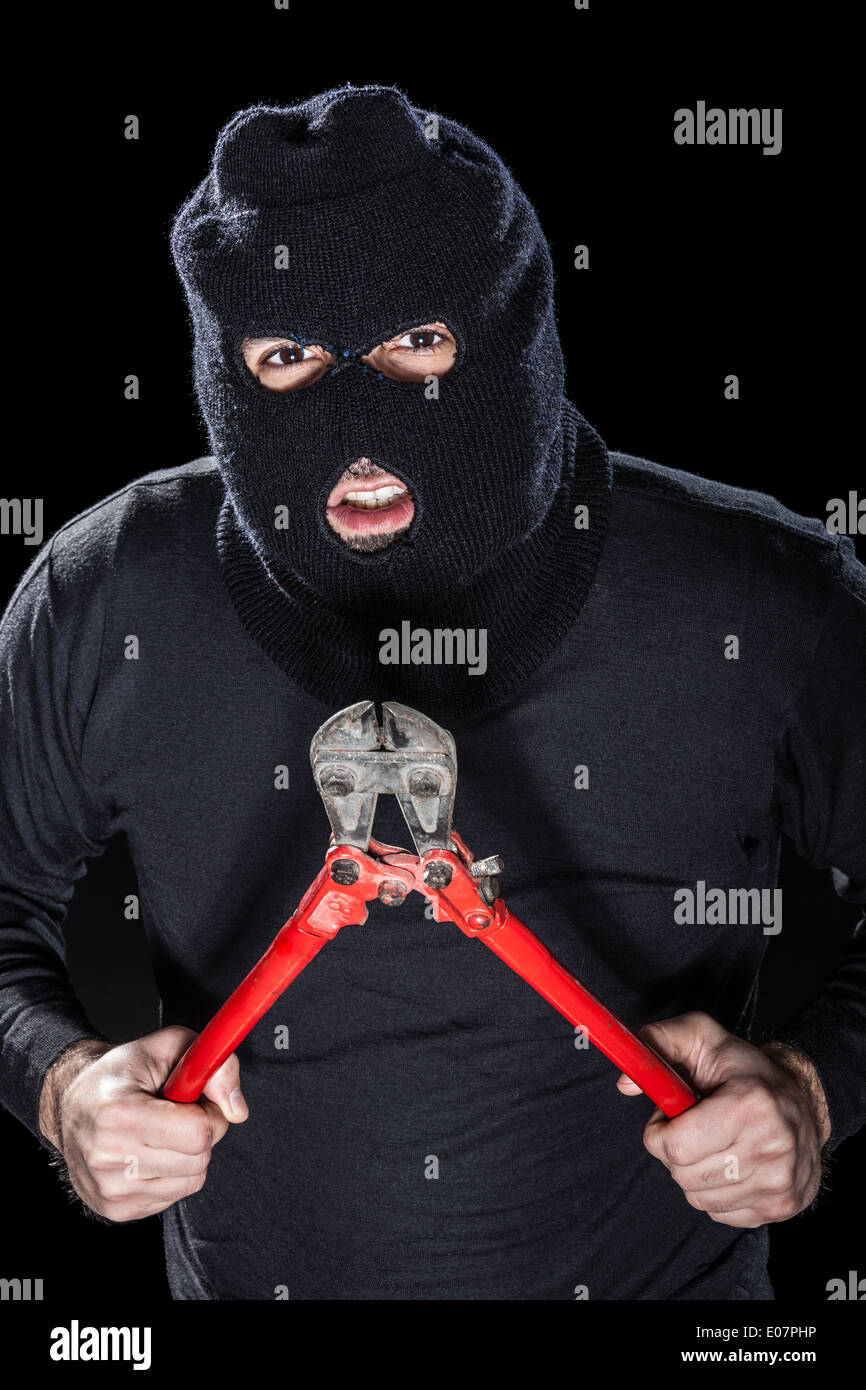 a burglar wearing a balaclava holding huge wire cutters over black ...