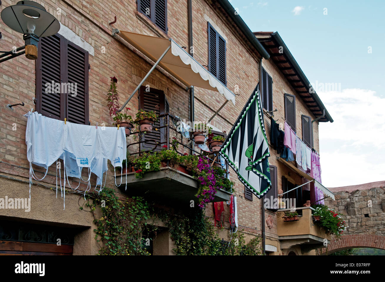 Flag washing and laundry hanging from veranda in Buonconvento Tuscany ...
