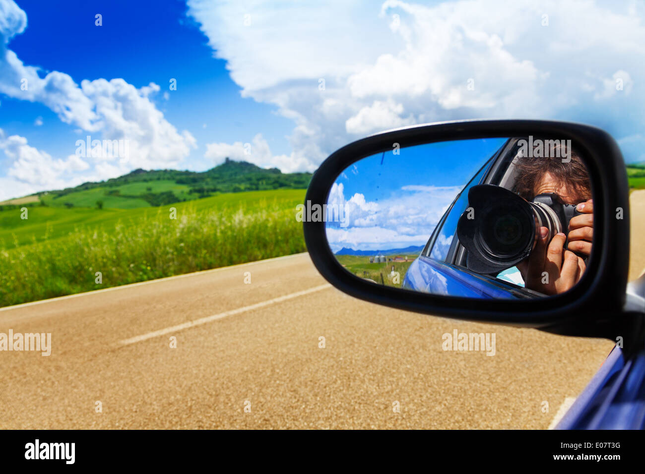 Photographer in car mirror drives near valley Stock Photo - Alamy