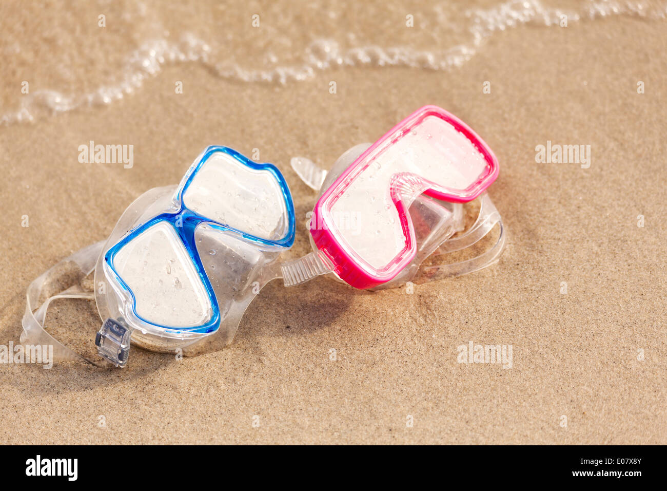 Fun water activity. two diving masks at the beach splashed by waves ...
