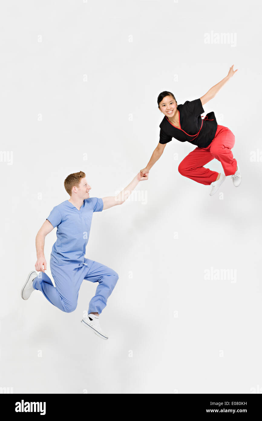 Dancing medical couple jumping happily in scrubs white seamless ...