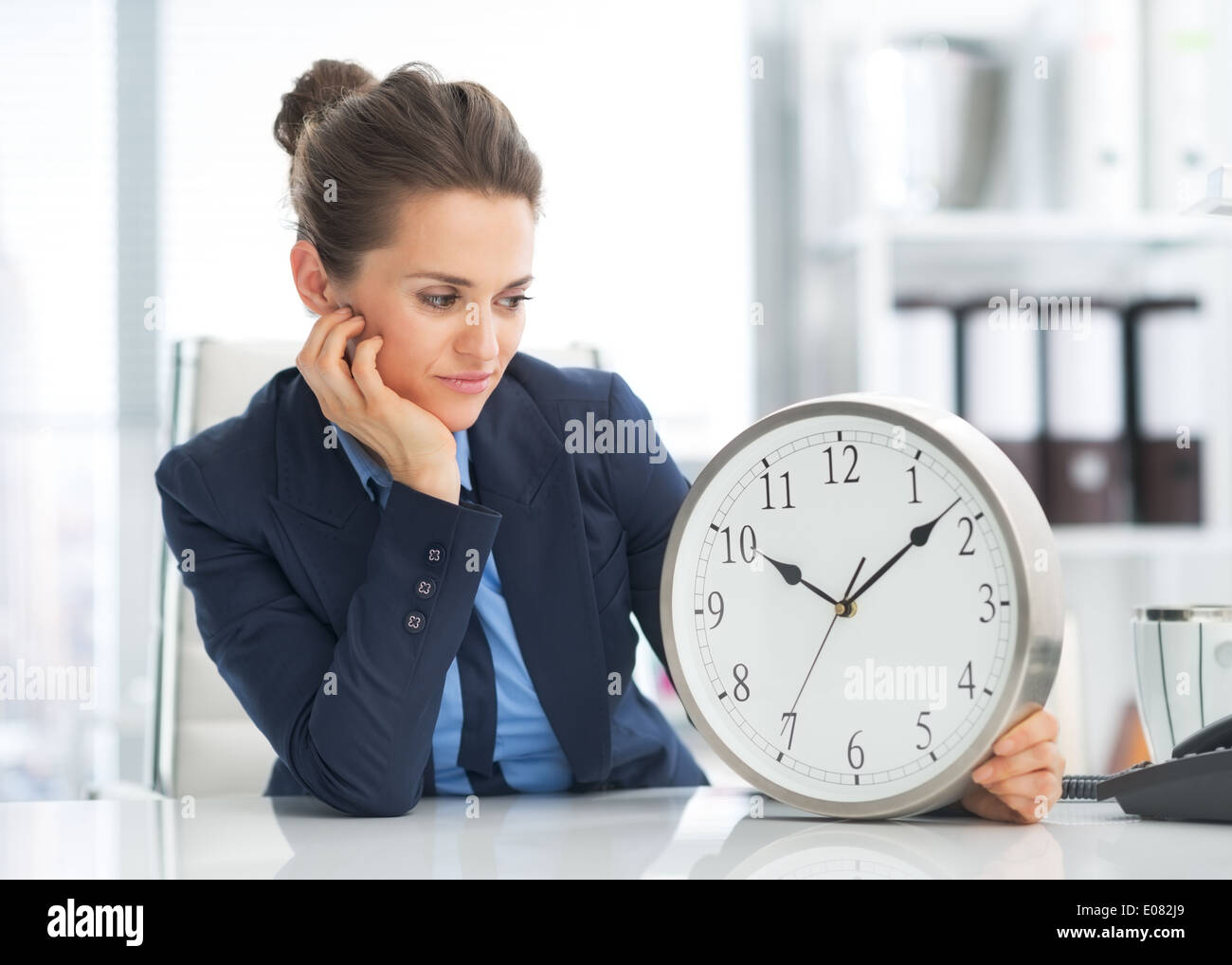 Office worker looking at clock hi-res stock photography and images - Alamy