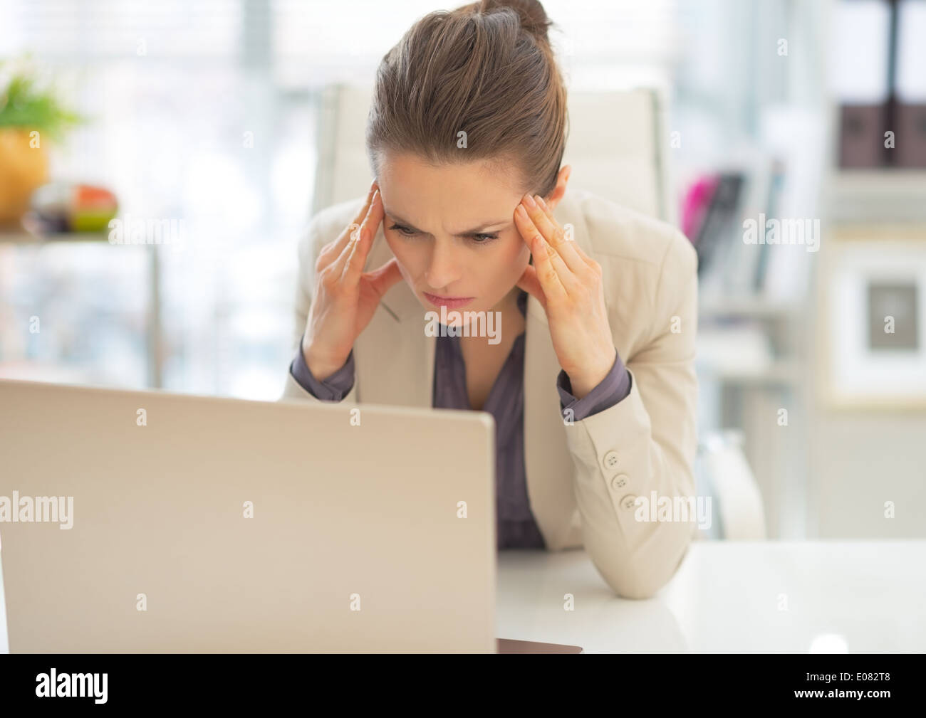 Stressed business woman with laptop at work Stock Photo - Alamy