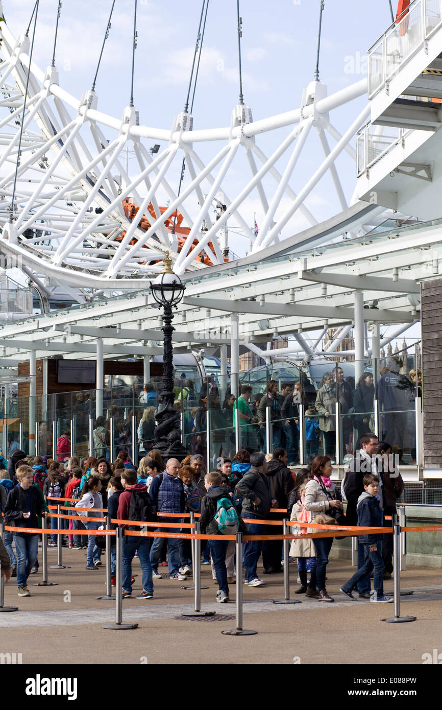 Tourists queuing to get on to the London eye in the city of London ...