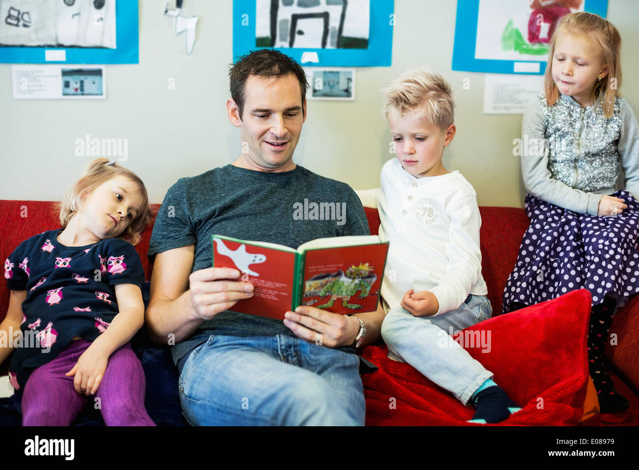 Male teacher reading story book for children in kindergarten Stock ...