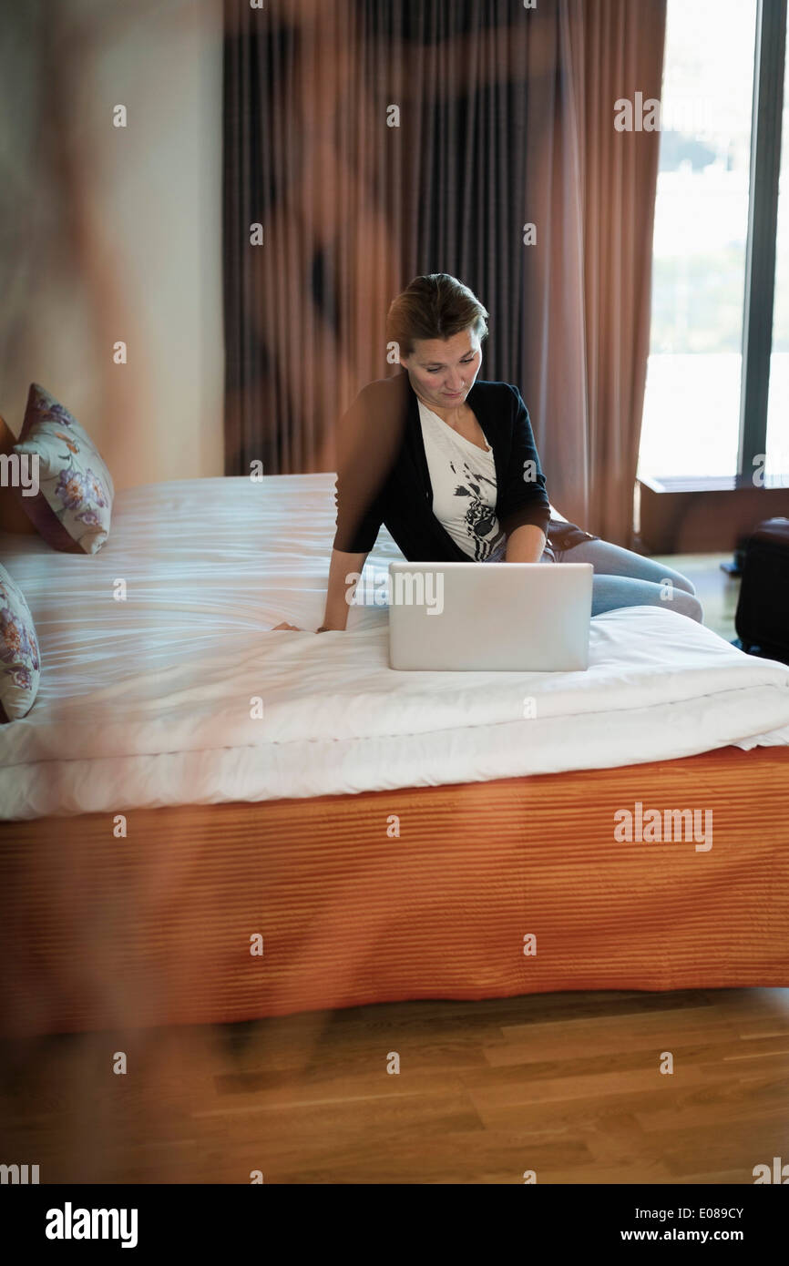 Businesswoman using laptop on bed in hotel room Stock Photo - Alamy Businesswoman using laptop on bed in hotel room Stock Photo - Alamy