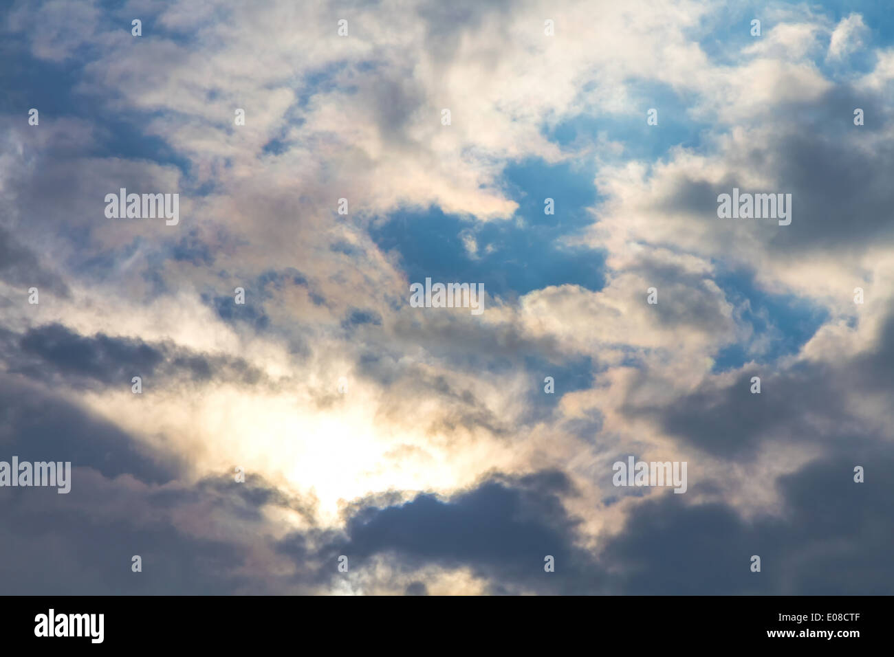 Sun under clouds on blue sky background Stock Photo - Alamy