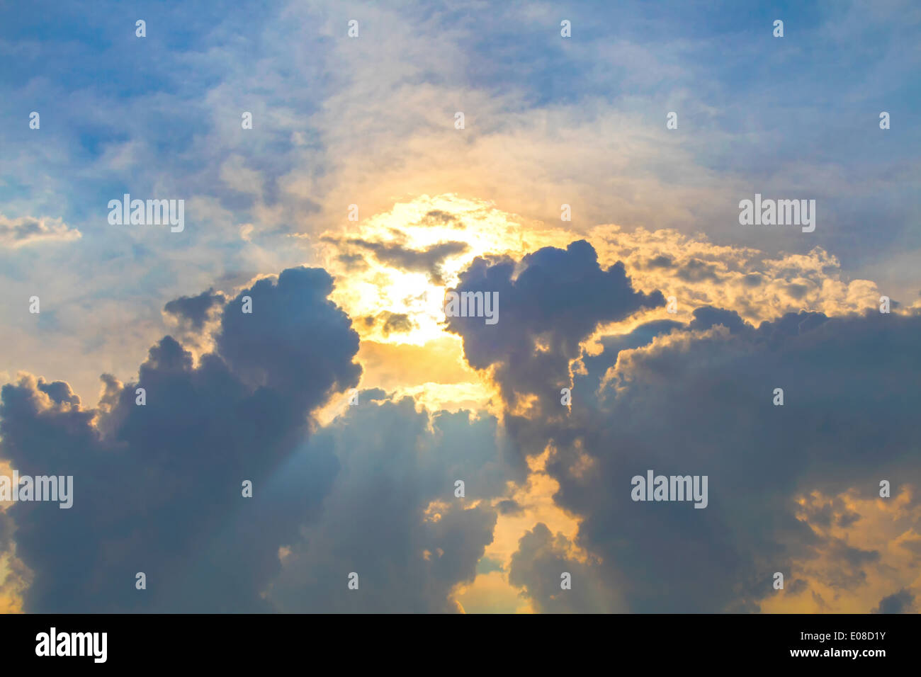 Sun under clouds on blue sky background Stock Photo - Alamy