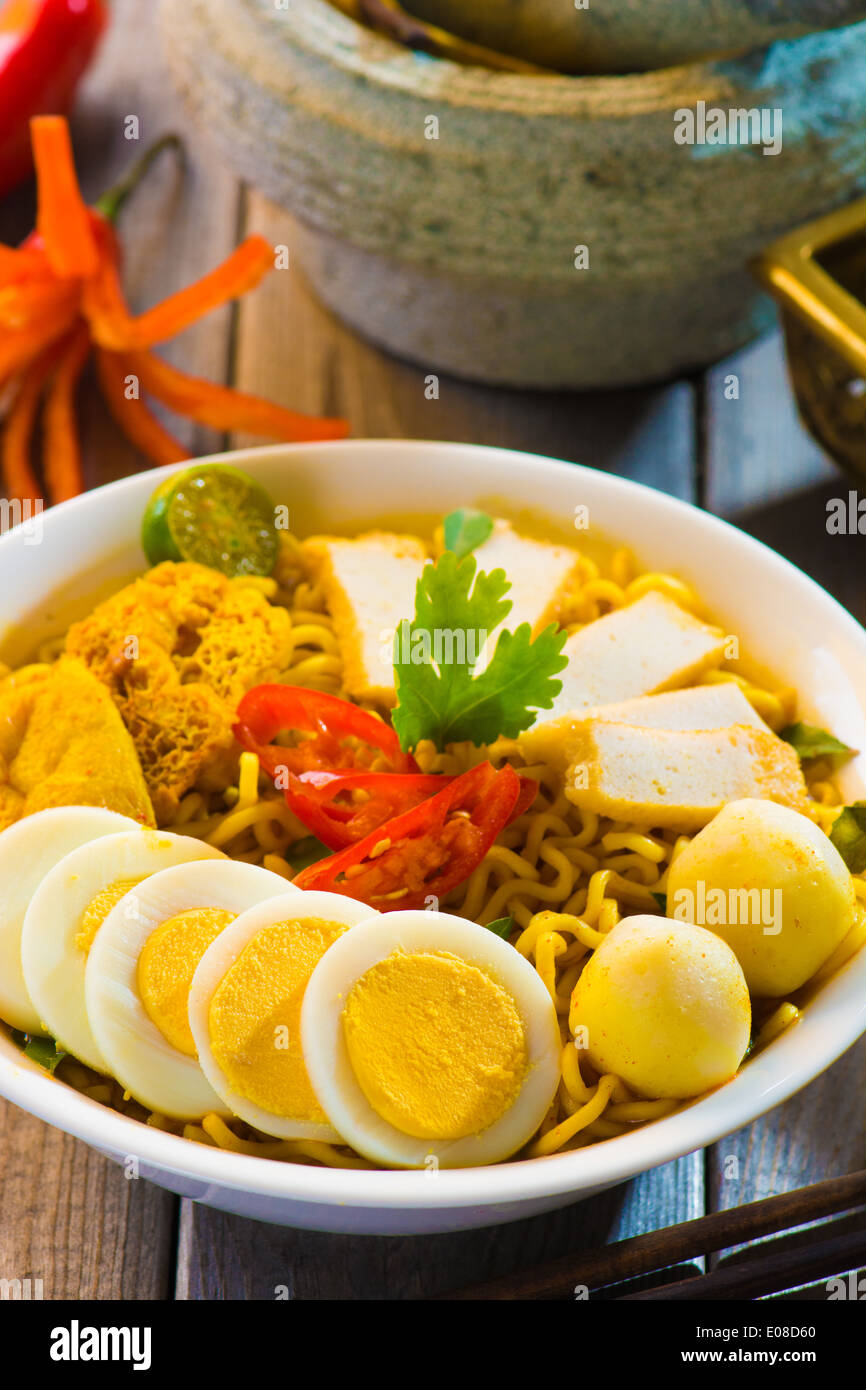 Spicy curry instant noodles. Asian cuisine, ready to serve on wooden ...