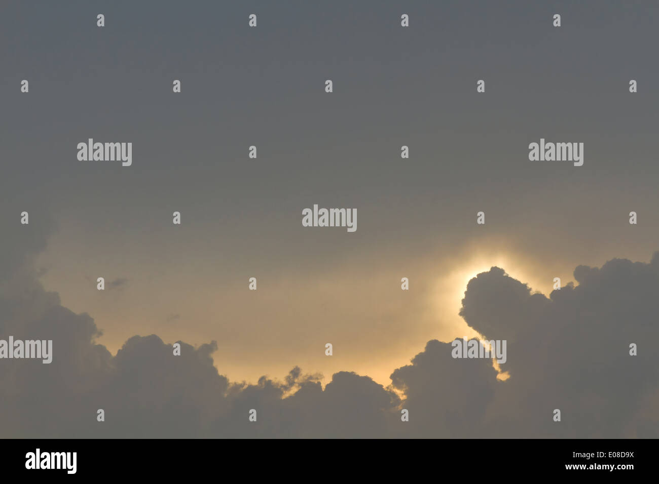 Sun under clouds on blue sky background Stock Photo - Alamy