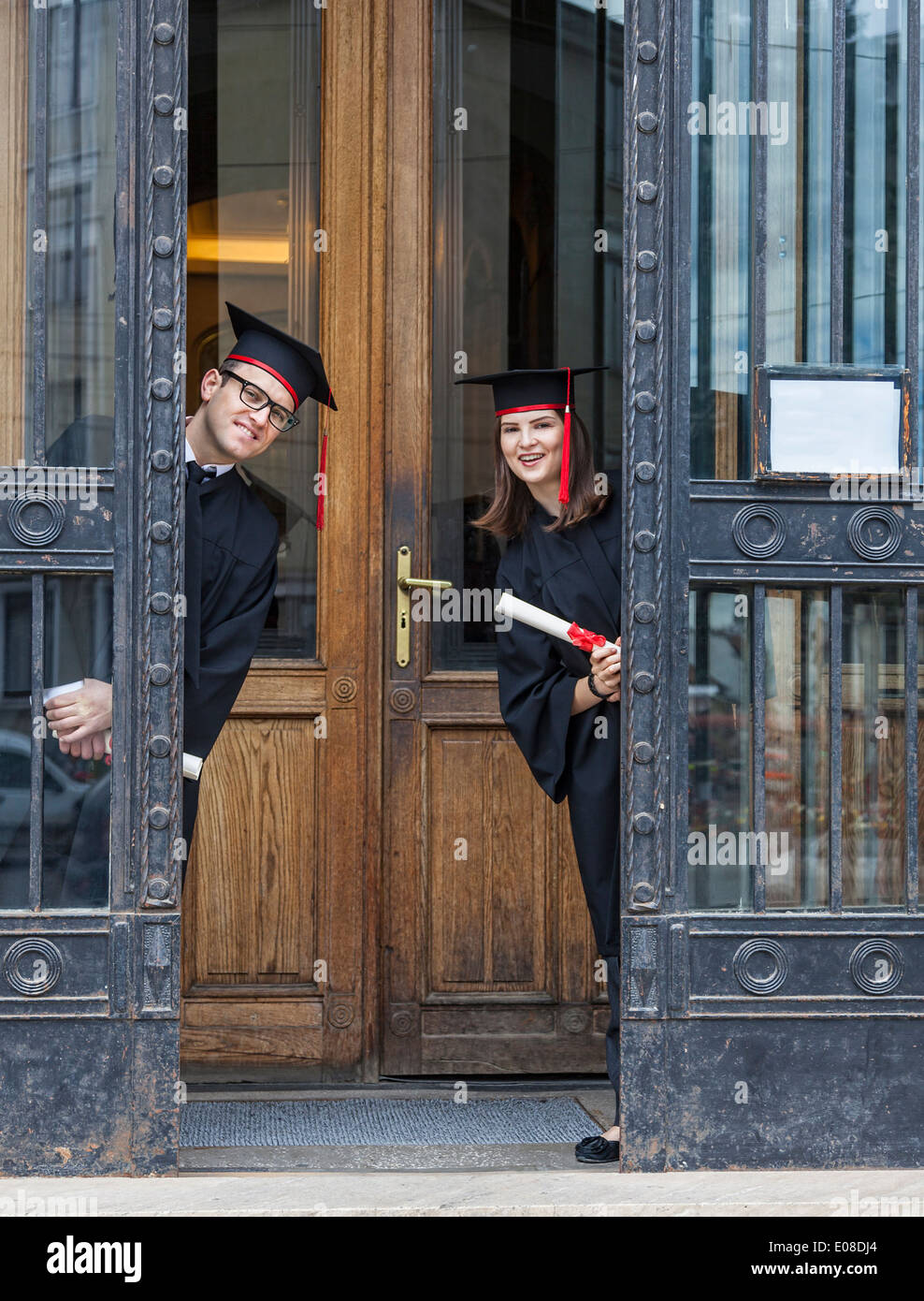 Young couple in the graduation day having fun at the gate of the ...