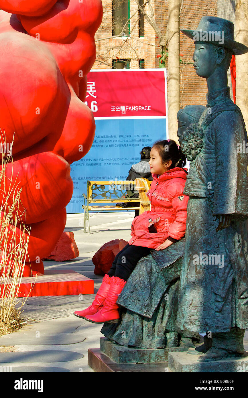 Young Chinese Girl Poses For A Photo With A Statue In The 798 Art Zone ...
